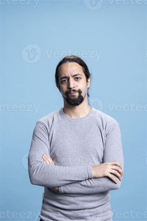 Male Person With Serious Facial Expressions Standing Against Blue