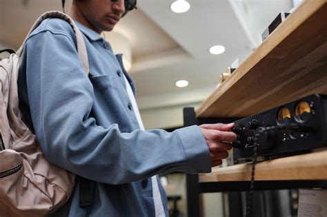 Premium Photo Closeup Of Young Man Unplugging Equipment In Music Store Copy Space
