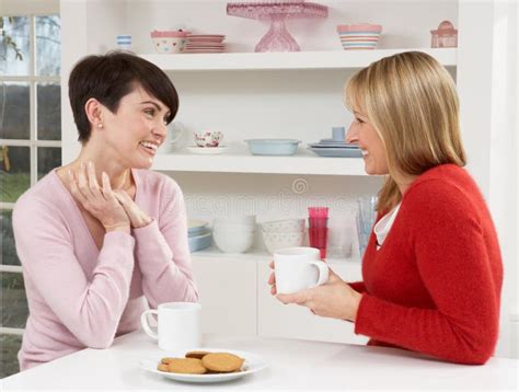 Two Women Enjoying Hot Drink In Kitchen Stock Image Image Of Kitchen