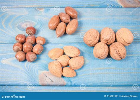 Different Types Of Nuts In A Shell On A Wooden Background Stock Image