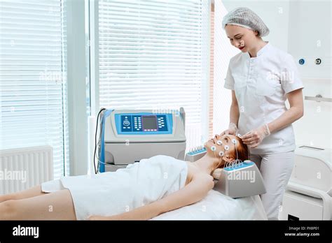 Woman With Electrodes On Her Face Receiving Electric Stimulation On