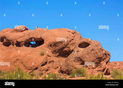 Hole In The Rock Cave In Red Sandstone With Climbing Tourists Usa