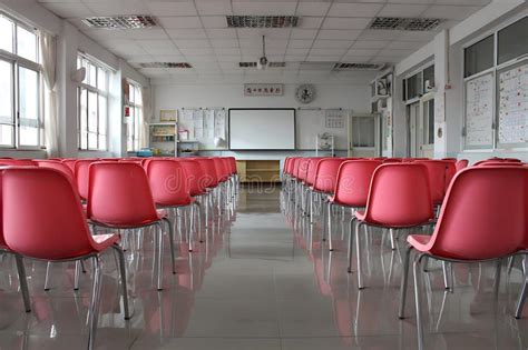 Empty Classroom With Red Chairs And Whiteboard In Modern School Stock