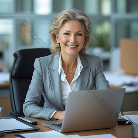 Smiling Businesswoman Working At Her Desk Photo  Free Download