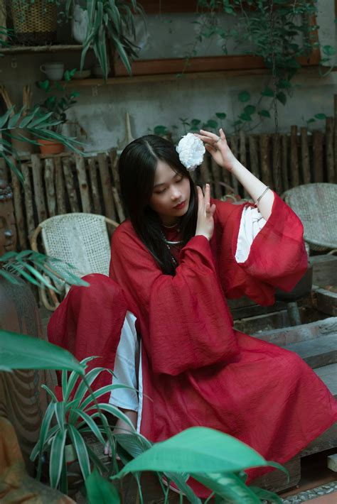 빨간 기모노를 입은 여자가 의자에 앉아 있다 사진 Unsplash의 무료 의류 이미지