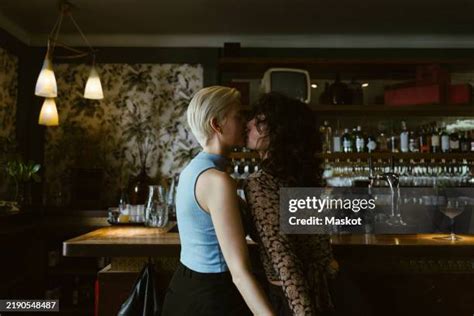 Affectionate Lesbian Couple Kissing At Bar Counter In Restaurant High
