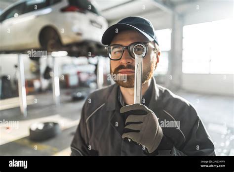 Repair Shop Worker Looking Through A Hole In A Spanner Medium Shot Blurred Background High