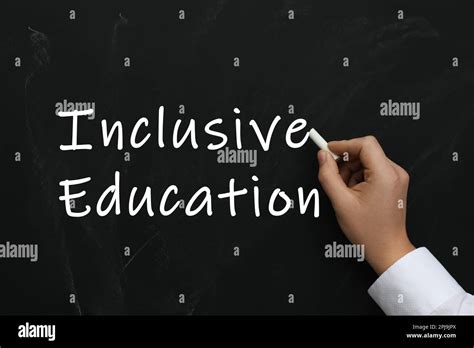 Woman Writing Phrase Inclusive Education On Blackboard Closeup Stock