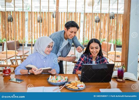 Group Of Happy University Students Using Laptop When Working On