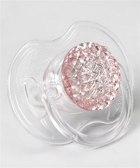 A Pacifier With Pink Glitter On The Top And Bottom Sitting In A Clear