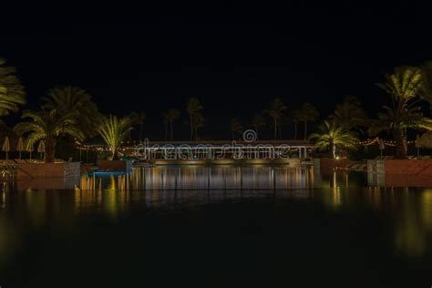 A Beautiful Night View Of The Hotel Grounds With An Outdoor Pool And
