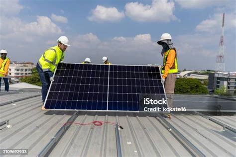 기술자는 공장 지붕에 태양광 모듈을 설치합니다 엔지니어는 공장 지붕에 태양 전지를 설치하거나 고정합니다 태양 전지판의 기술자 작업자 공장 지붕에서 일하는 태양열 기술자 20
