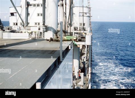 A Crewman Leans Over The Edge Of The Flight Deck Aboard The Aviation Logistic Ship Usns Wright