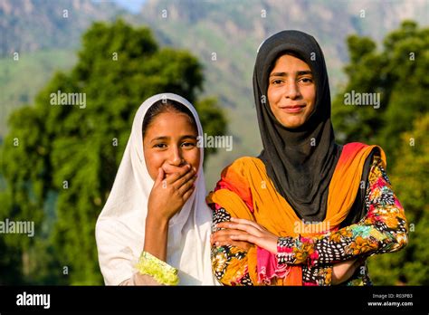 A Portrait Of Two Kashmiri Girls Covering Their Heads By A White And A