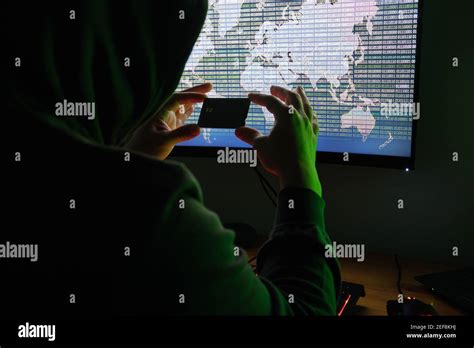 Hacker Holding A Credit Card Front Of A Computer For Organizing Massive