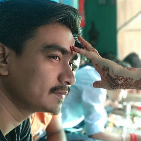 Premium Photo Woman With Henna Tattoo Applying Tilaka On Forehead Of Man
