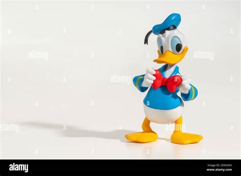 Plastic Donald Duck Figurine Adjusting His Red Bow Tie Isolated On A