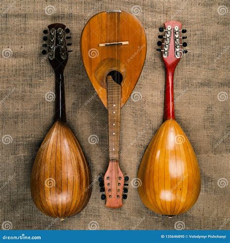 Three Old Mandolins On A Background Of Rough Burlap Texture Royalty