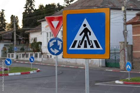 Multiple Street Signs In A Roundabout Pedestrian Crossing Right Of