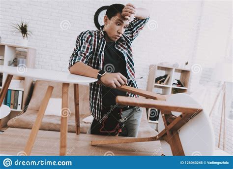 Young Man Assembling Coffee Table And Stools Stock Image Image Of