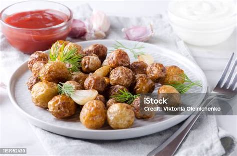 바삭한 크 러스트와 마늘 케 찹과 화이트 소스를 곁들인 맛 있는 볶은 새 감자로 가득 찬 접시의 근접 촬영 감자 요리에 대한 스톡 사진 및 기타 이미지 Istock