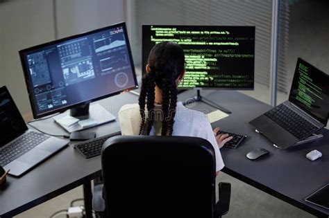 Back Of Female It Programmer Coding On Multiple Computers At Desk In Office Stock Image Image