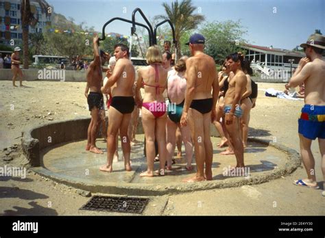 Group Of People In Fresh Water Shower On Beach After A Dip In The Dead