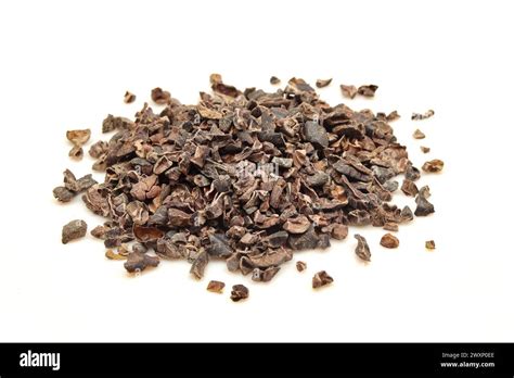 pile of crushed cocoa beans nibs isolated on white background stock