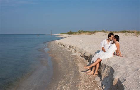 Junge Paare In Der Liebe Die Auf Dem Strand Sitzt Stockfoto Bild Von