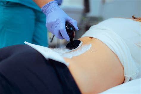 Nurse Massaging The Back Of A Patient With Ultrasound Machine Stock