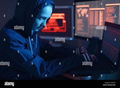 Girl Hacker In A Hood Typing Program Code While Committing A Cybercrime Hacking A System
