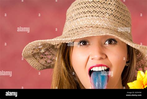 Beautiful Woman Sticking Out Her Blue Tongue With A Nice Hat In A Pink