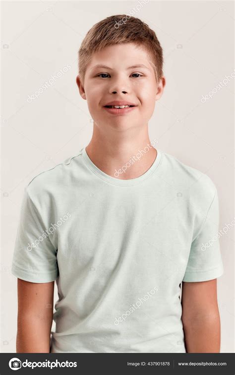 Portrait Of Cheerful Disabled Boy With Down Syndrome Smiling At Camera