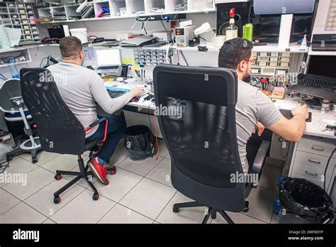 The Employees In The Workshop Do Their Daily Work A Workbench Full Of Various Tools And Items