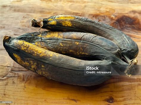 Closeup Image Of Hand Of Overripe And Rotting Bananas Black And Yellow