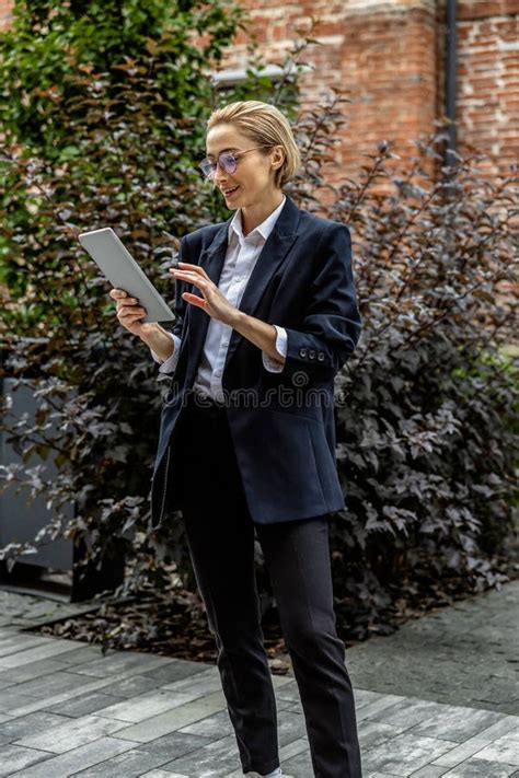 Cute Young Manager In Jacket And Pants With A Tablet Looking Busy Stock