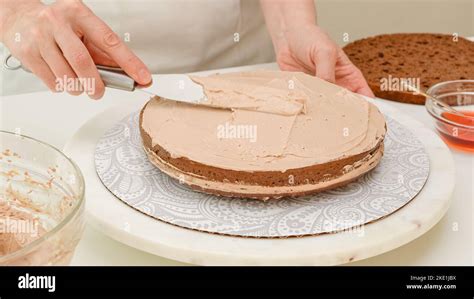 Assembling The Cake Woman Hands Topping Part Of The Cake With Chocolate Cream Step By Step