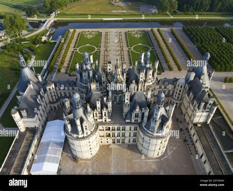 Detailed View Of A Historic Castle From The Air With Many Towers And Green Areas All Around