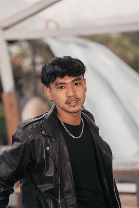 A Grown Man In A Black Leather Suit And Chain Necklace Posing Very