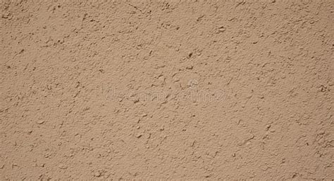 A Textured Beige Wall Displays A Rough Uneven Surface With Numerous