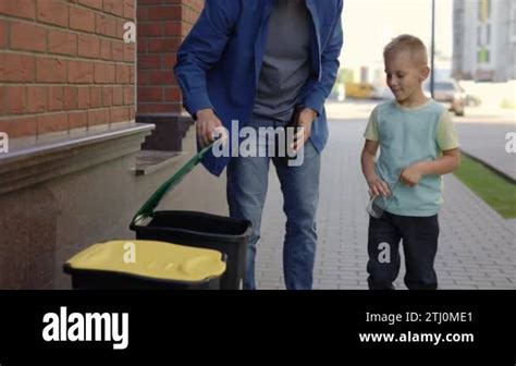 Dad Teaches His Son To Properly Sort Garbage Father And Son Sorting The Glass Properly Ecology