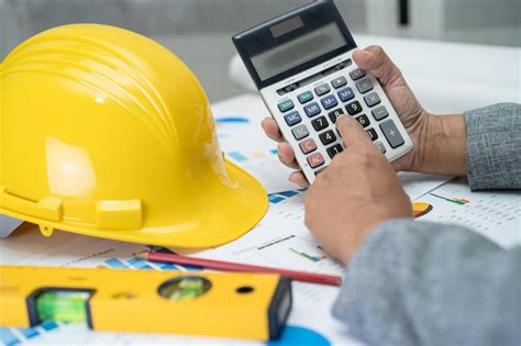 Premium Photo Asian Engineer With Architectural House Plan Project Blueprint Graph And Yellow