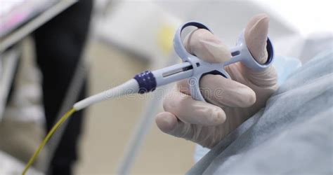 Close Up The Doctor Holds An Endoscopic Biopsy Clamp In His Gloved