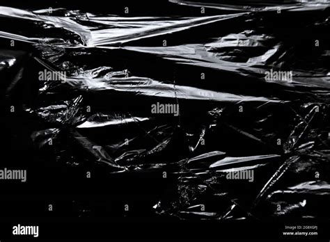 Photo Of The Polyethylene Surface With Ragged Hole On Black Background