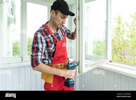 Handyman Adjusting White Pvc Plastic Window Indoors Worker Using Screwdriver To Repair Upvc