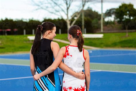 Image Of Aboriginal Sisters On Netball Court With Arms Around Each