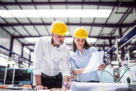 Two Project Managers Standing In Modern Industrial Factory