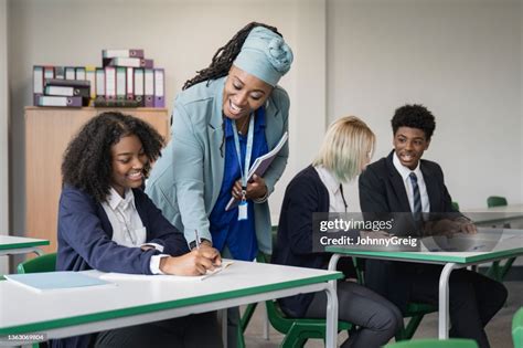 Un Enseignant Joyeux Aide Un Élève En Classe Secondaire Photo Getty