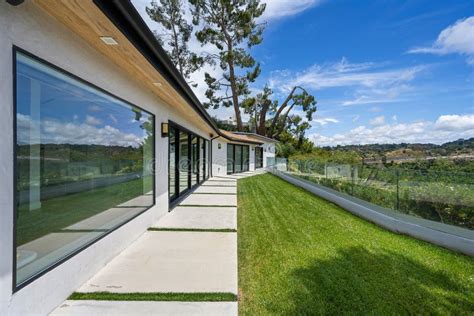 Spacious Grassy Backyard With A Porch Providing A Scenic View Of The