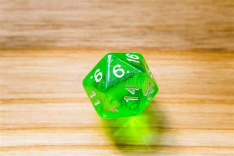 A Translucent Green Twenty Sided Playing Dice On A Wooden Background With Number Six On A Top